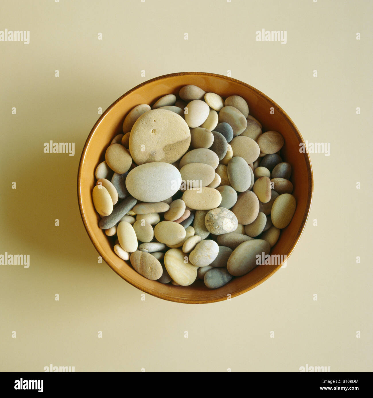 Still-Life of collection of small smooth pebbles in earthenware bowl ...
