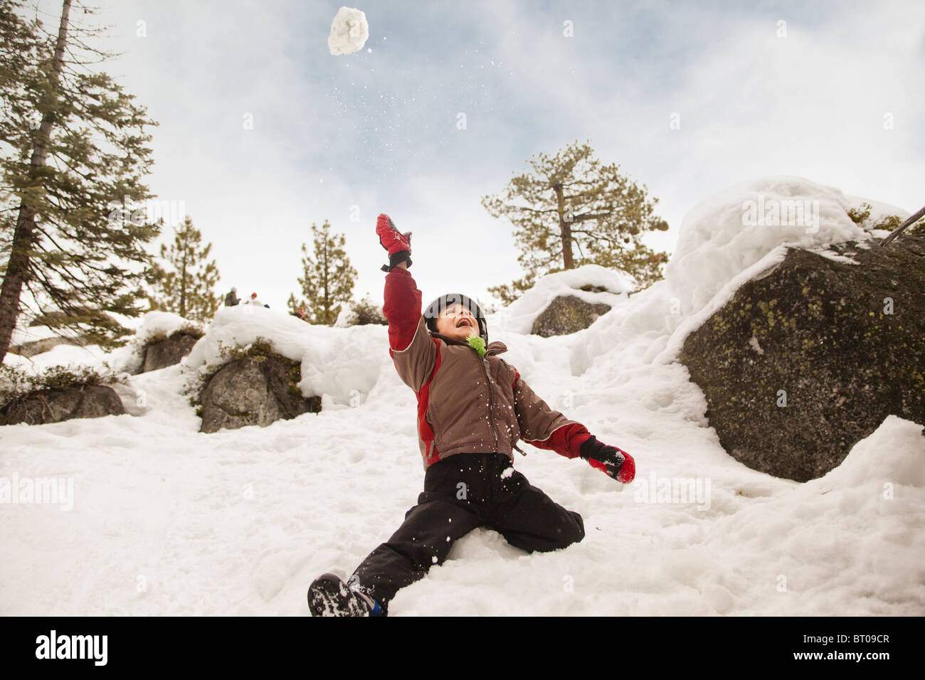 Boy throwing snowball overhead Stock Photo - Alamy