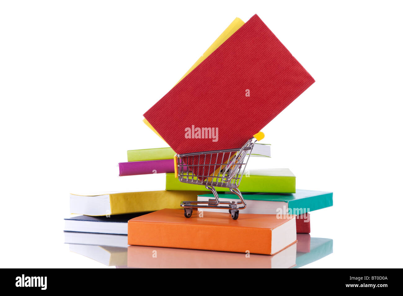 Stack of color books and a shopping cart (isolated on white Stock Photo ...