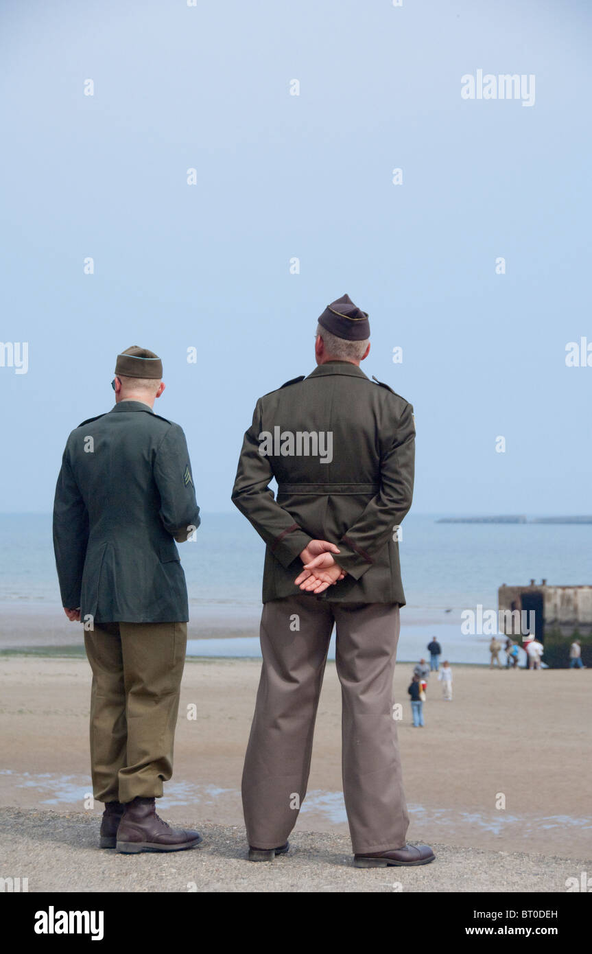 France, Normandy, Arromanches. Men in uniform overlooking famous ...