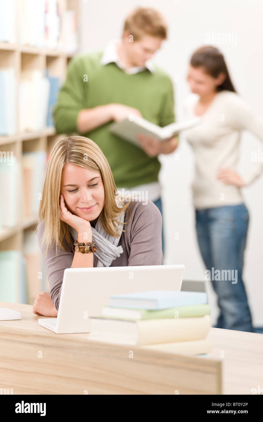 High school library - female student with laptop and book Stock Photo ...