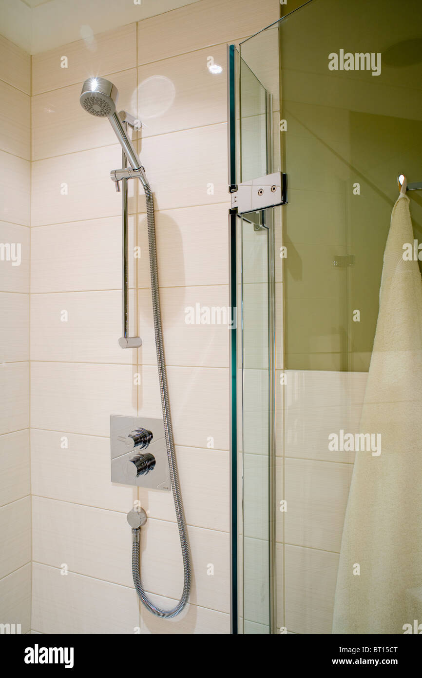 Stainless steel shower and cream wall tiles in modern bathroom Stock ...