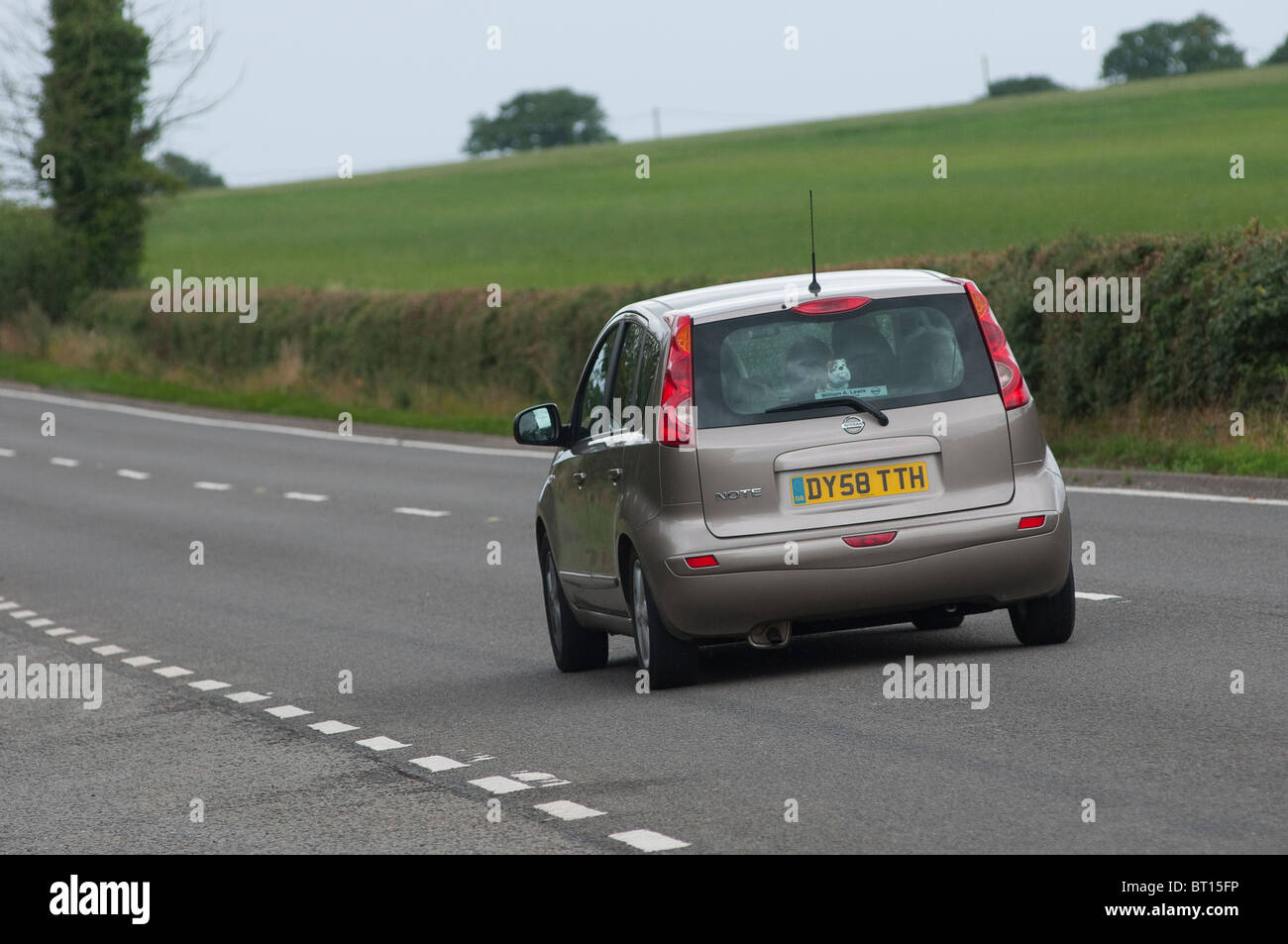 Rear view of a Nissan Note car travelling along a road in the English ...