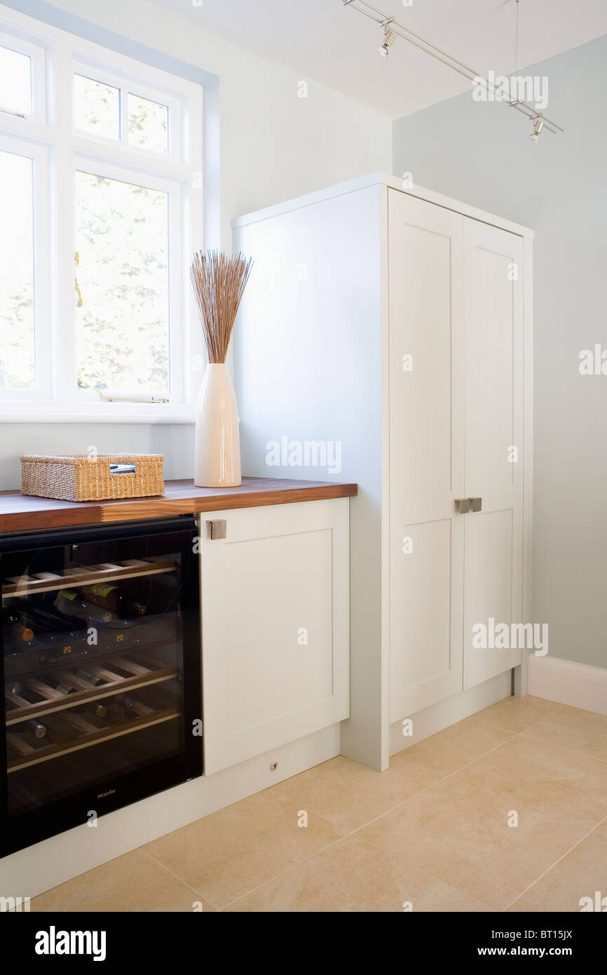 Wine cooling storage cooling unit beside large white fitted cupboard in ...