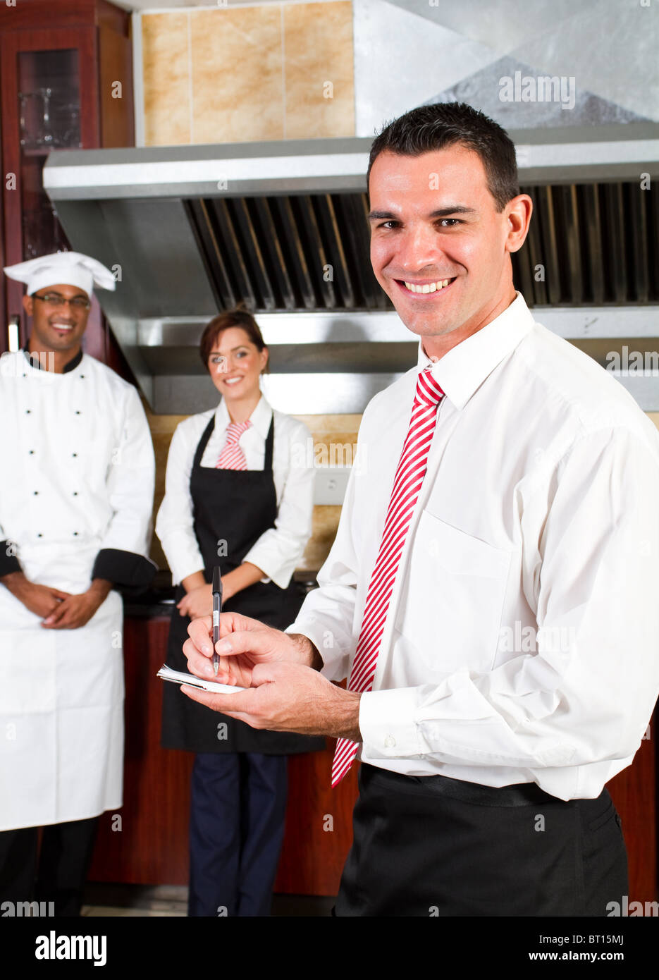 young happy male restaurant manager and his staff in kitchen Stock ...