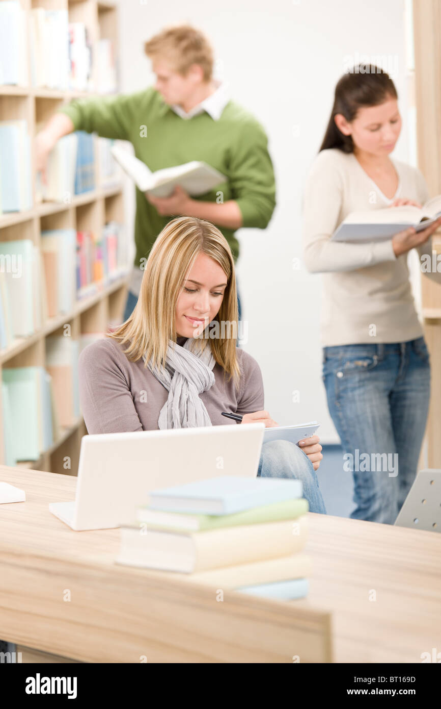 High school library - female student with laptop and book Stock Photo ...