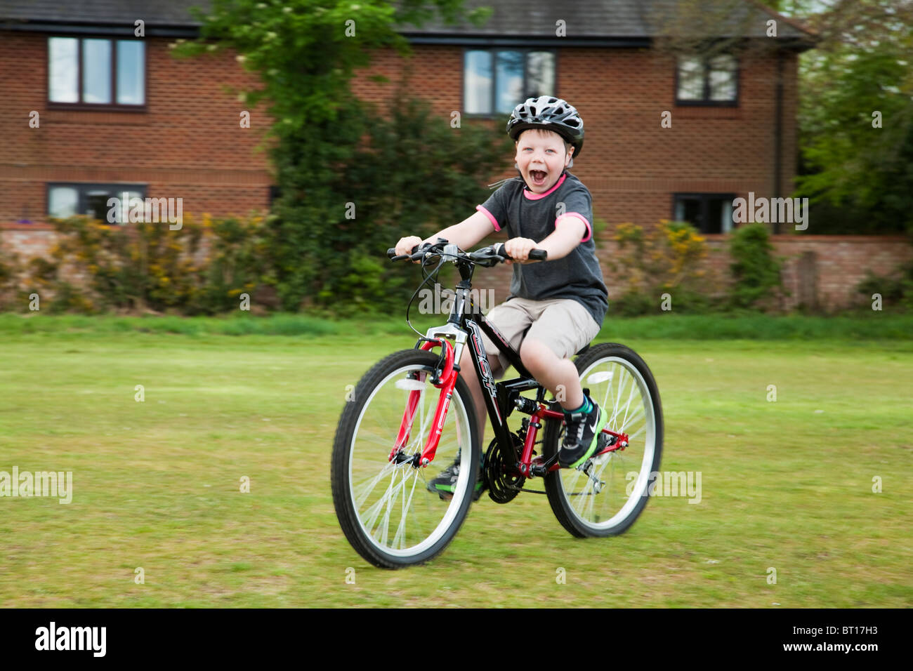 Young boy learning to ride his bike at the village park Stock Photo - Alamy