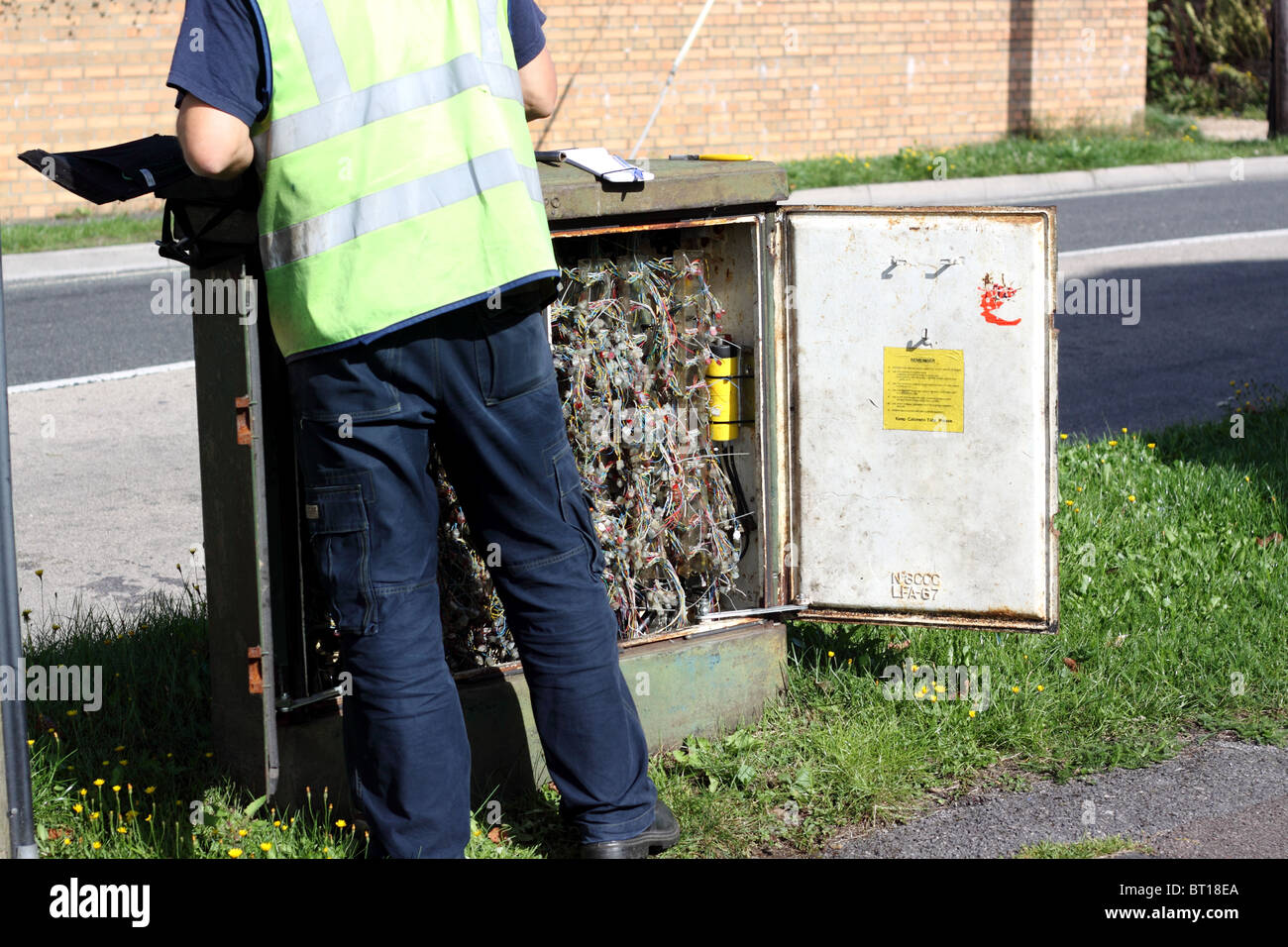a British Telecom Telephone Engineer examining a junction box or ...