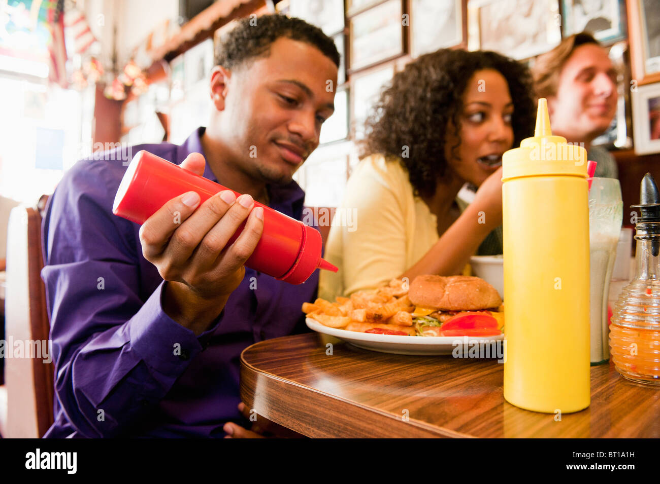 Friends eating in diner booth Stock Photo - Alamy