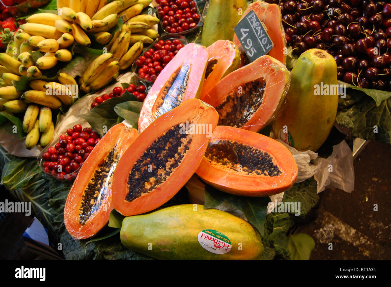 Fruit stand displays papaya, bananas and cherries at La Boqueria market ...