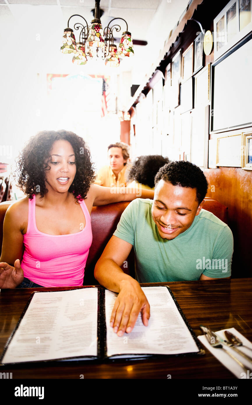 Smiling couple reading menu in diner Stock Photo - Alamy
