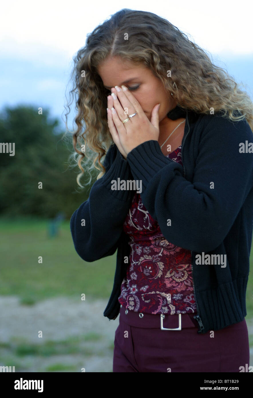 Stressed woman standing and thinking Stock Photo - Alamy