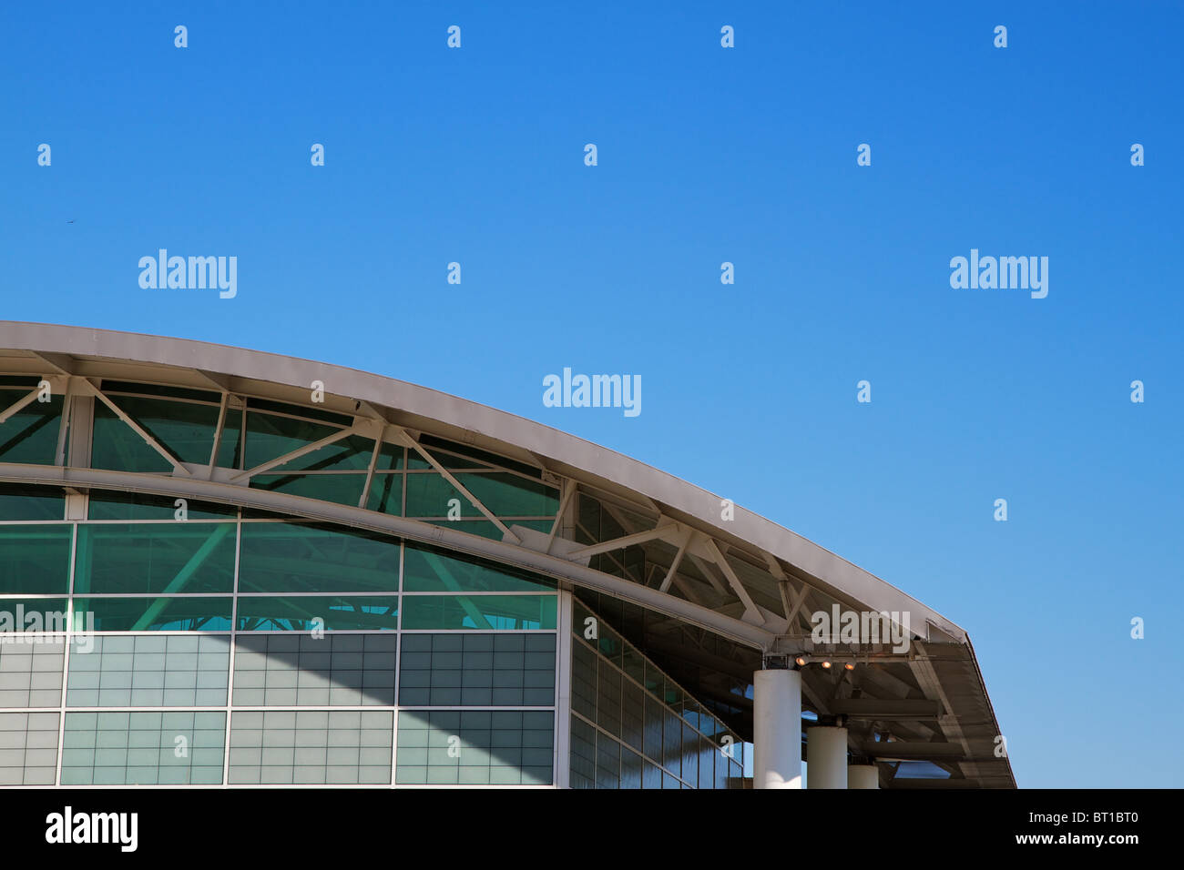 Arched roof sports complex building aginst a cloudless blue sky Stock ...