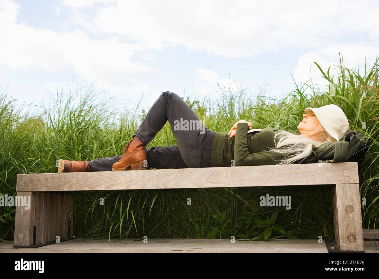 Caucasian woman laying on bench Stock Photo - Alamy