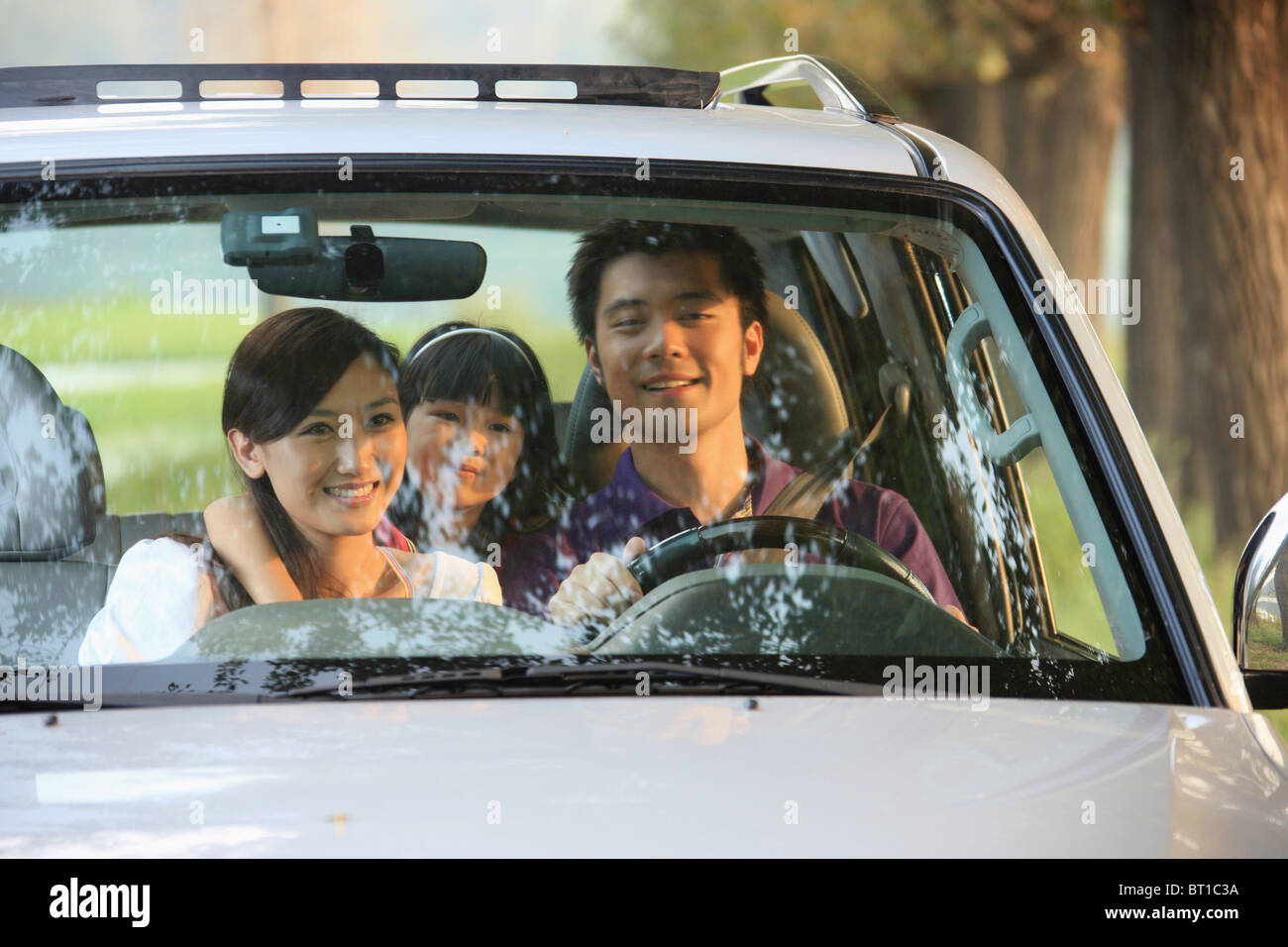 Young girl with her parents in car Stock Photo - Alamy