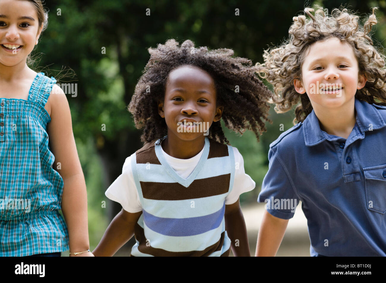 Smiling children holding hands and running Stock Photo - Alamy