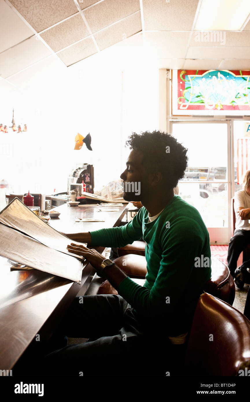 African American man reading menu at diner counter Stock Photo - Alamy