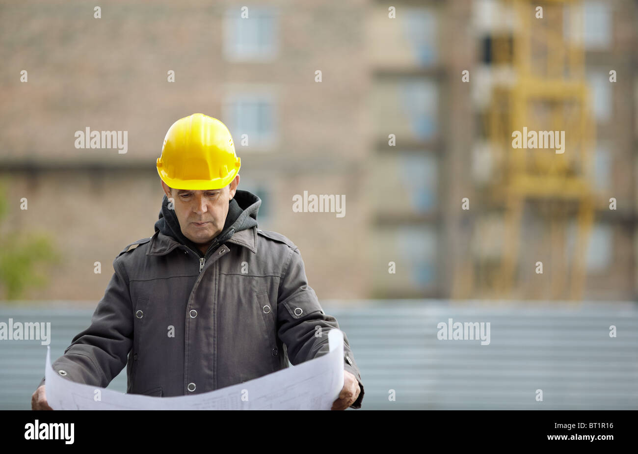 real builder with blueprints on construction site Stock Photo - Alamy