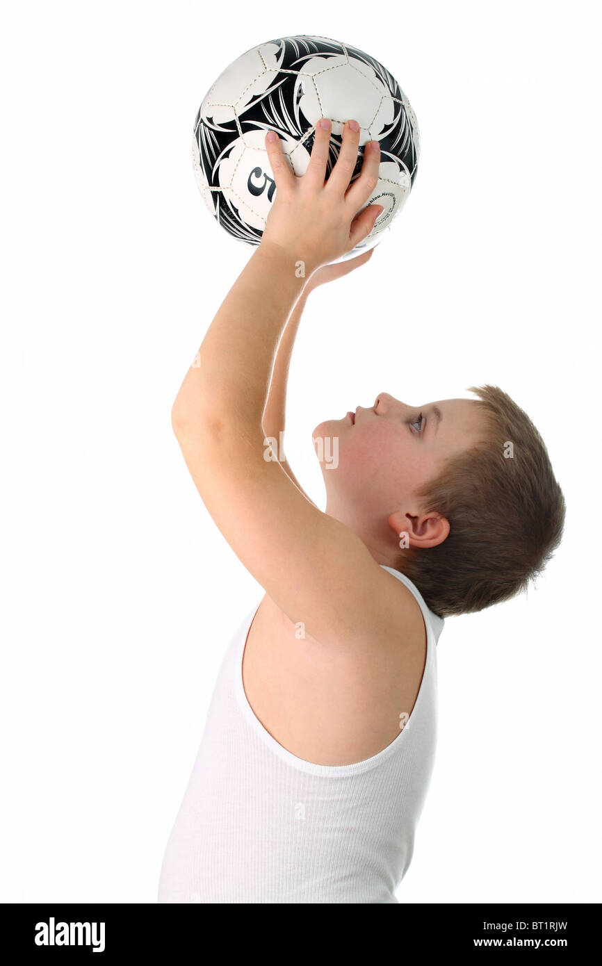 Unknown small boy holding soccer ball high above his head isolated on ...