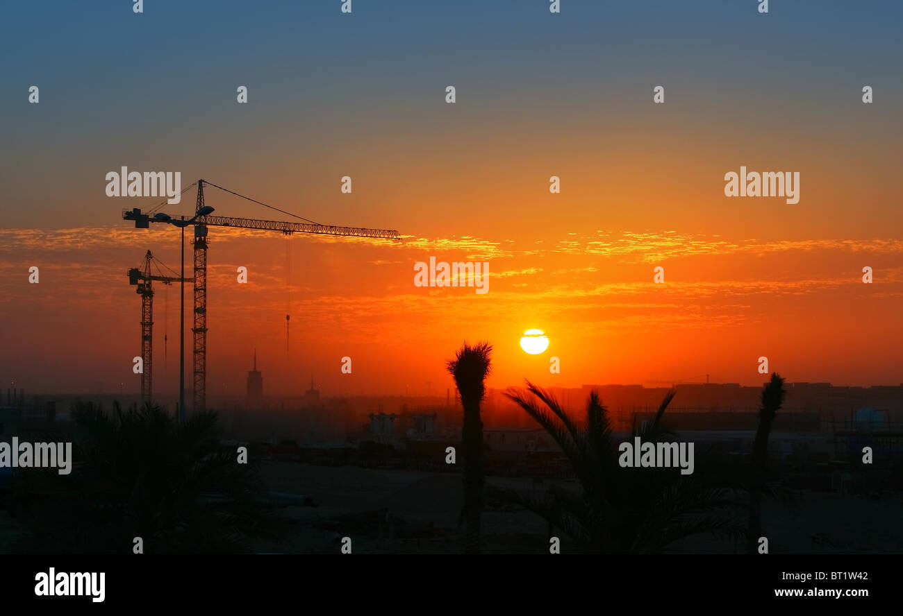 Construction crane over orange sunset sky Stock Photo - Alamy