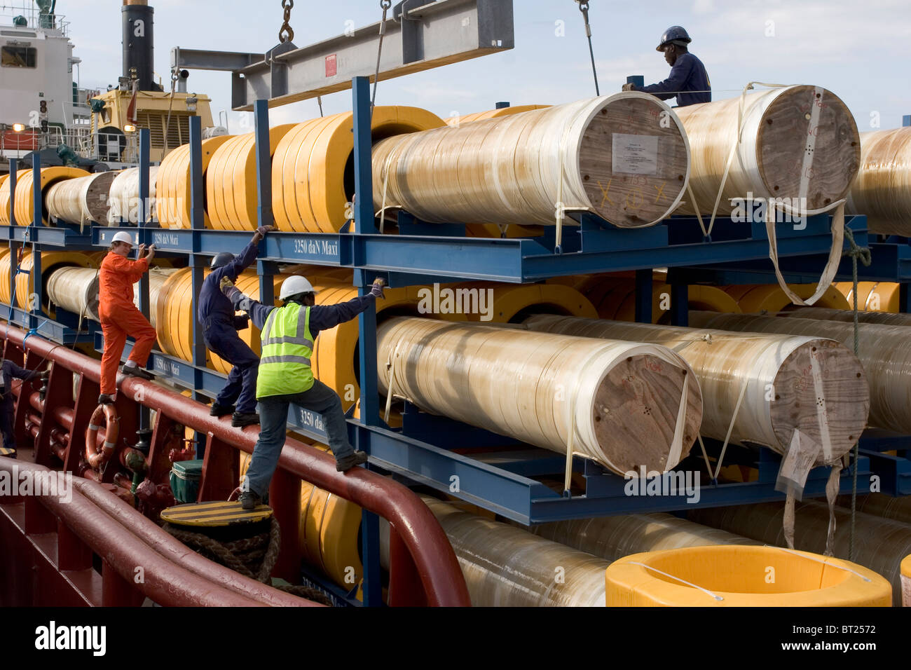 Luba Oil Freeport. Stevedores loading flexible submersible pipes onto ...