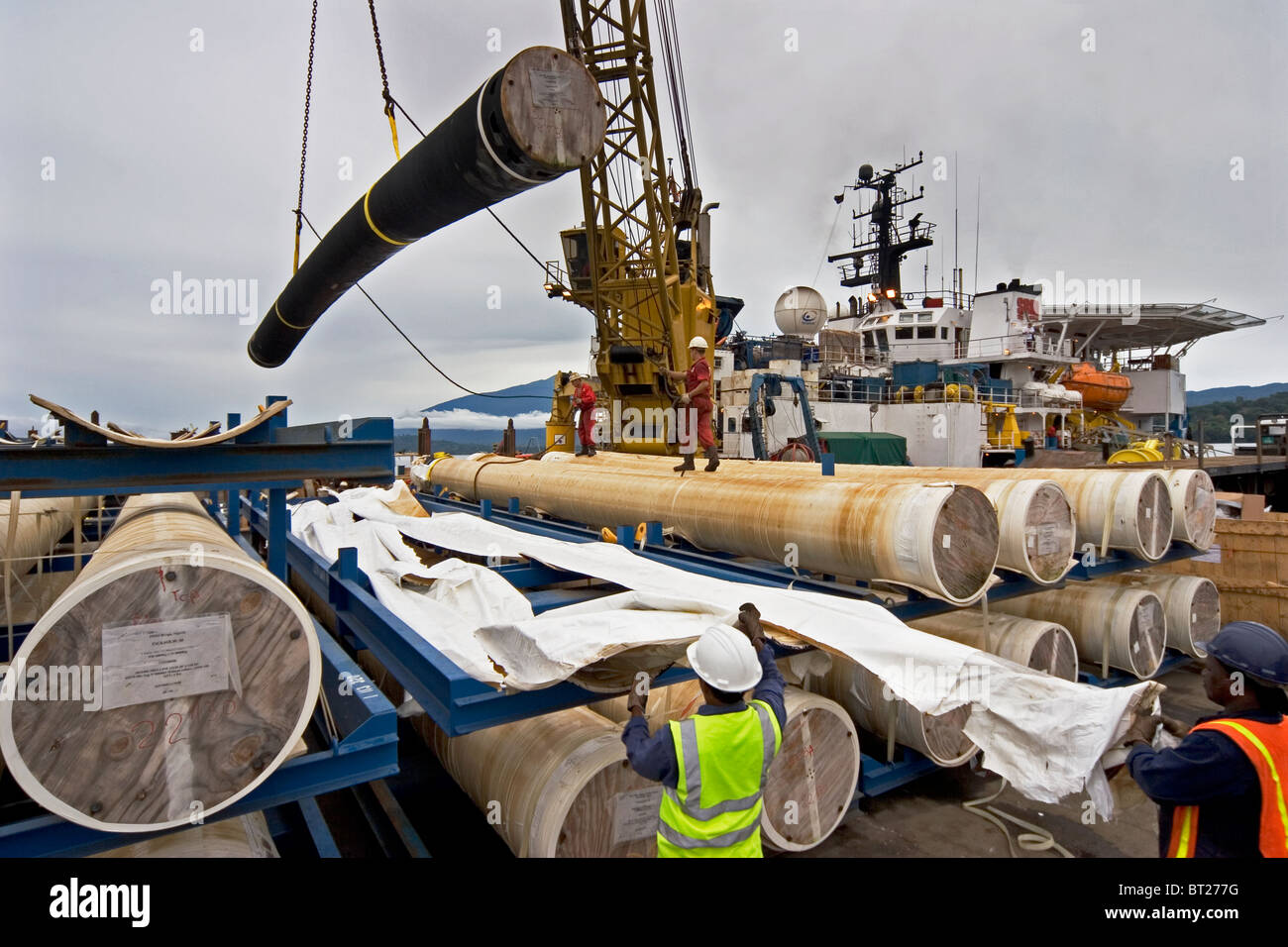 Luba Oil Freeport. Stevedores loading flexible submersible pipes onto ...