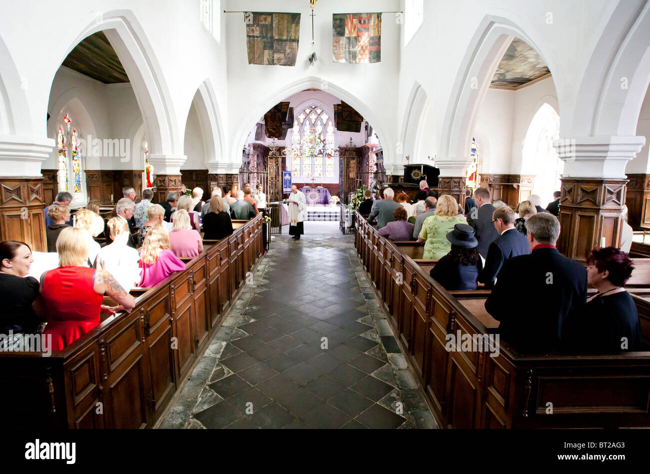 A congregation gather inside a Gothic English Church for a wedding ...