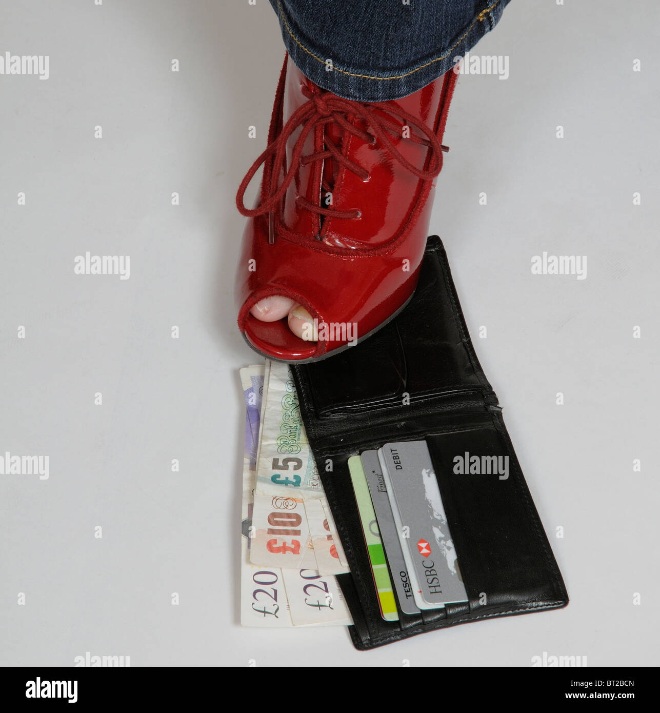 Woman standing on a man's money wallet on the floor Stock Photo - Alamy