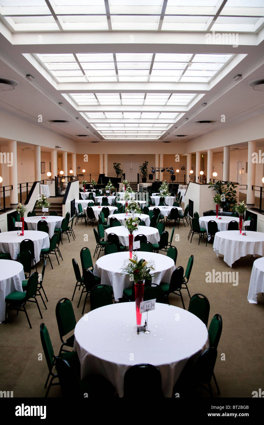 A glass roofed hall ready for a wedding reception and party to take ...