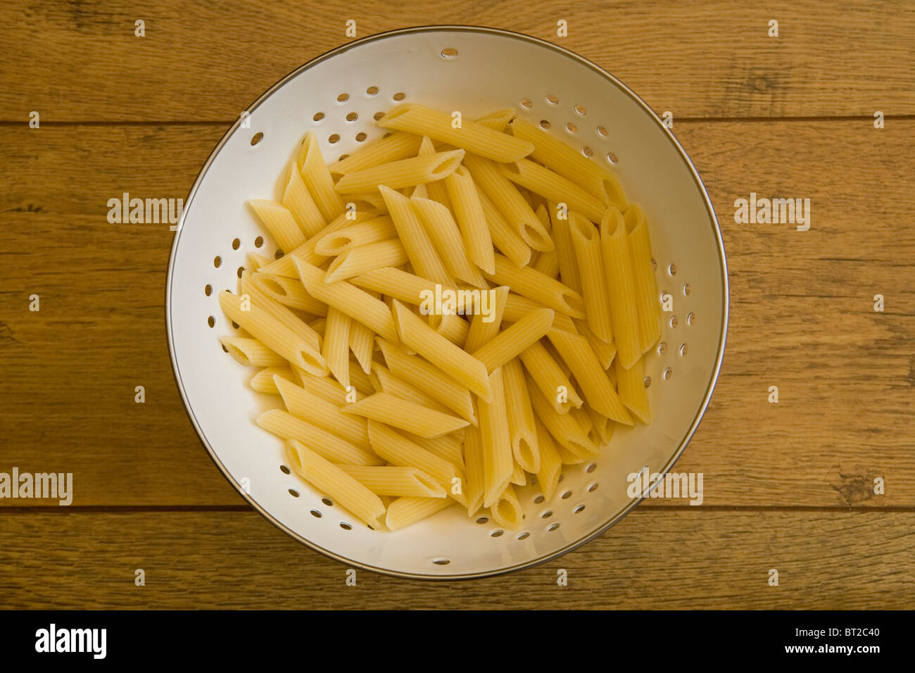 Pasta in colander on table Stock Photo - Alamy
