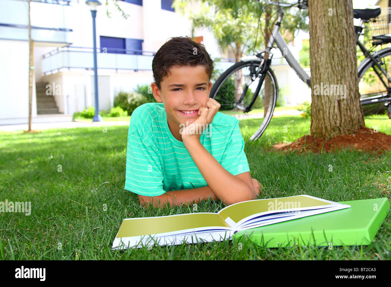 boy teen student homework laying green grass garden bycicle background ...
