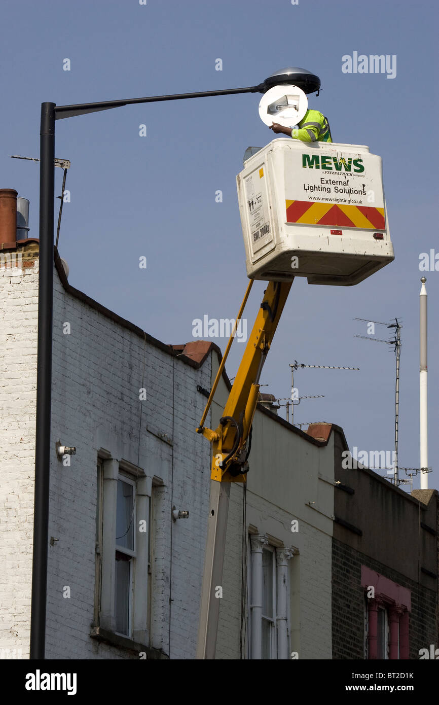 Repairing a bulb on top of a lamp post Stock Photo - Alamy