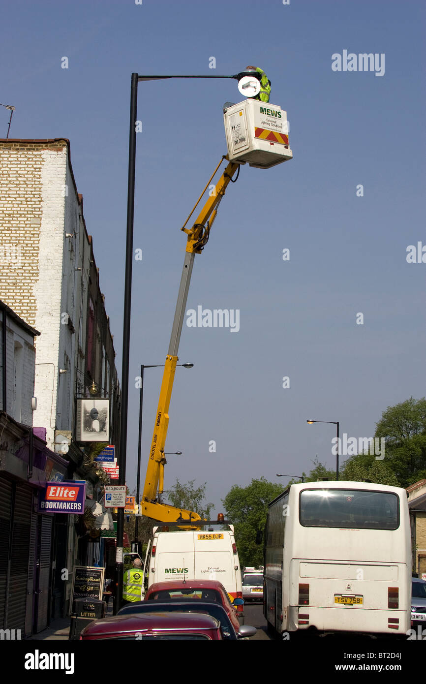 Repairing a bulb on top of a lamp post Stock Photo - Alamy