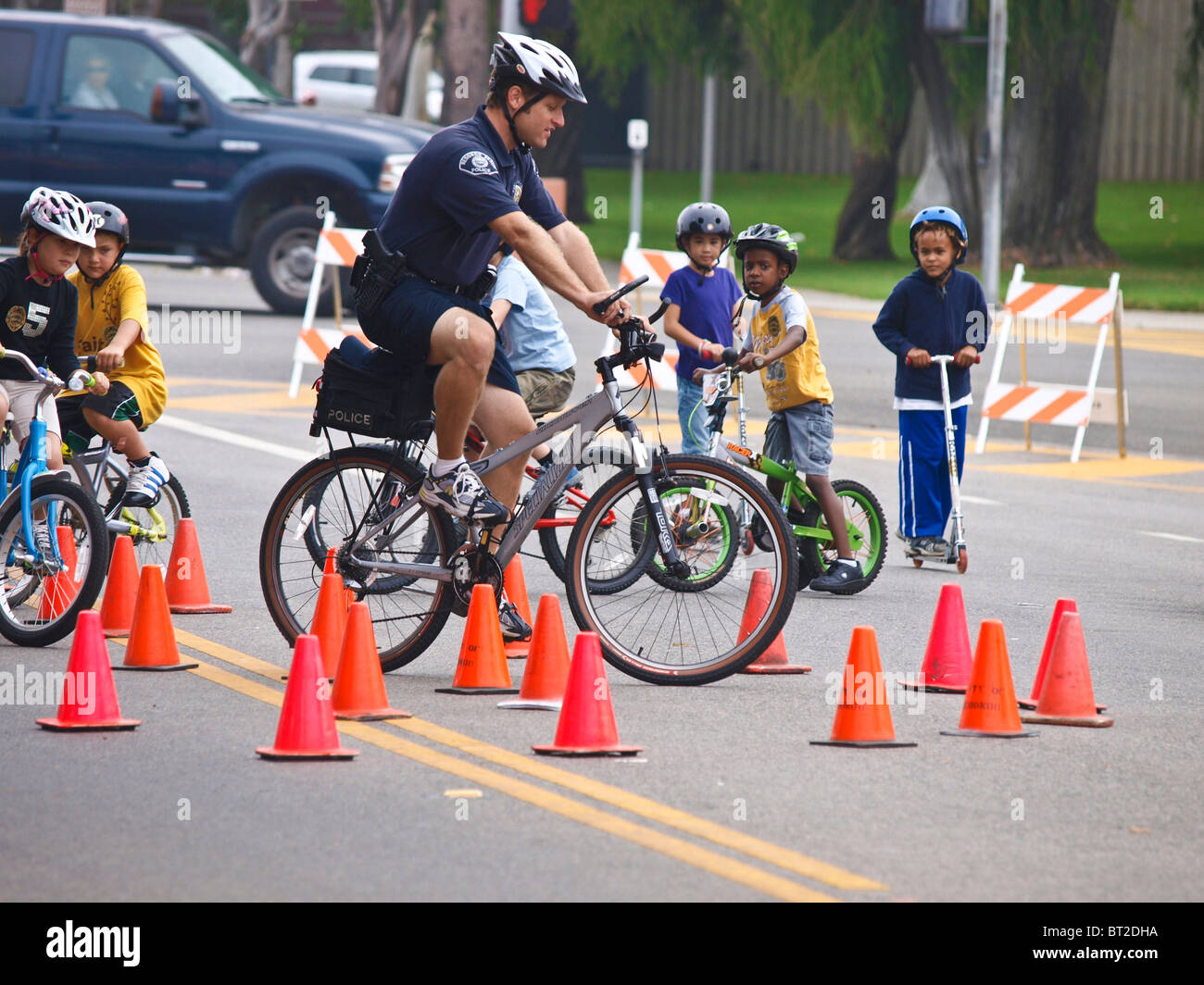 Youngsters follow police officer through pylons on their bikes Stock ...