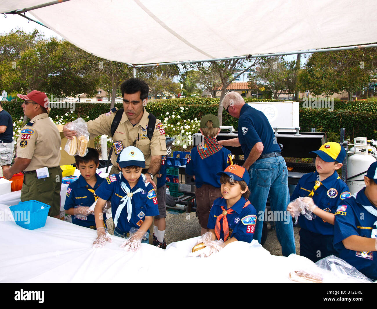 Cub scouts and their adult counterparts prepare and serve free hot dogs ...