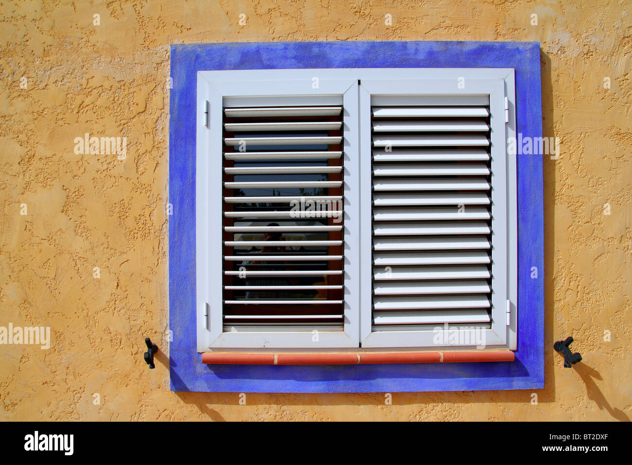 Mediterranean wood window blue frame yellow wall Stock Photo - Alamy