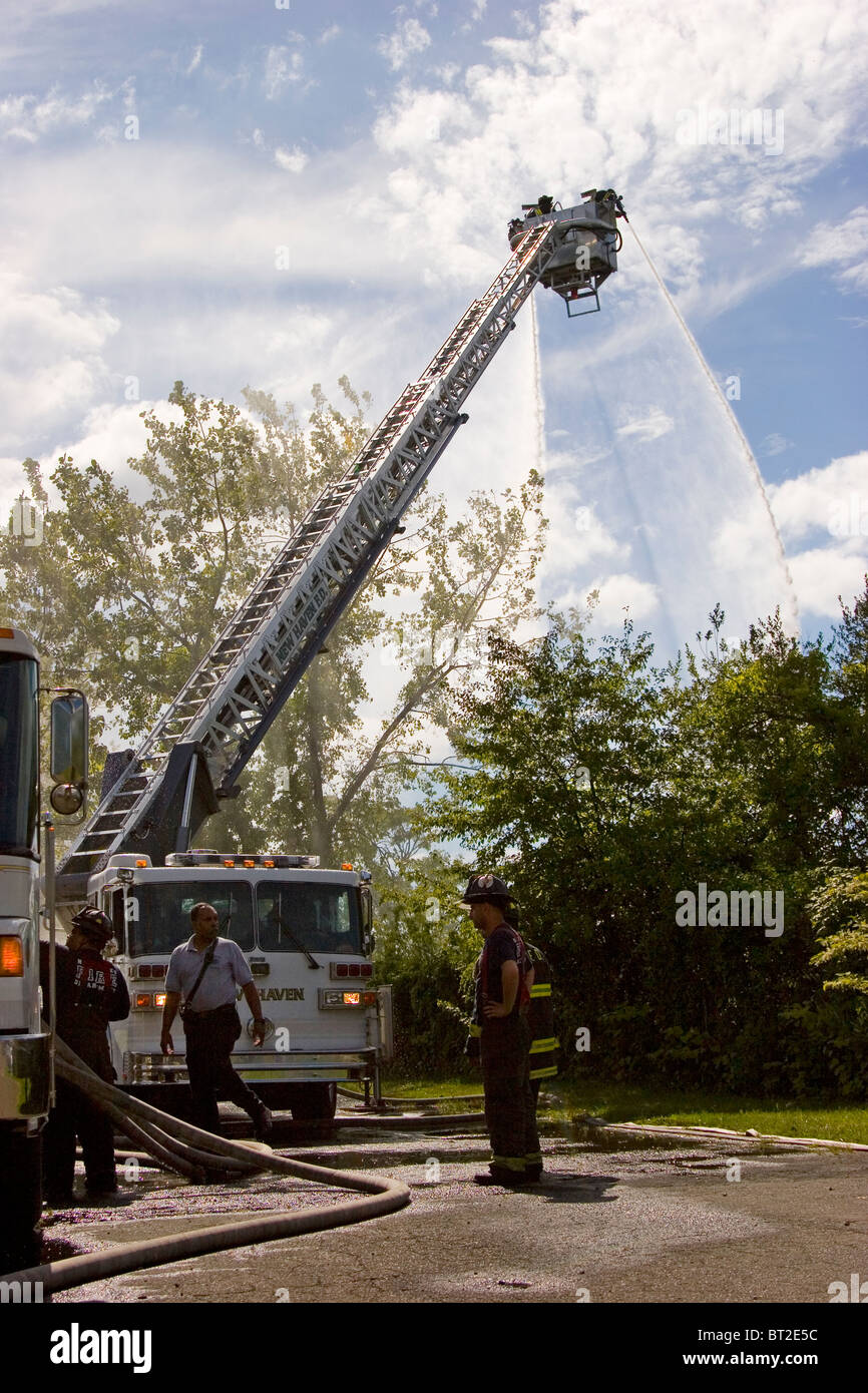 Firefighters training on ladder truck with hoses, firetruck and ladder ...