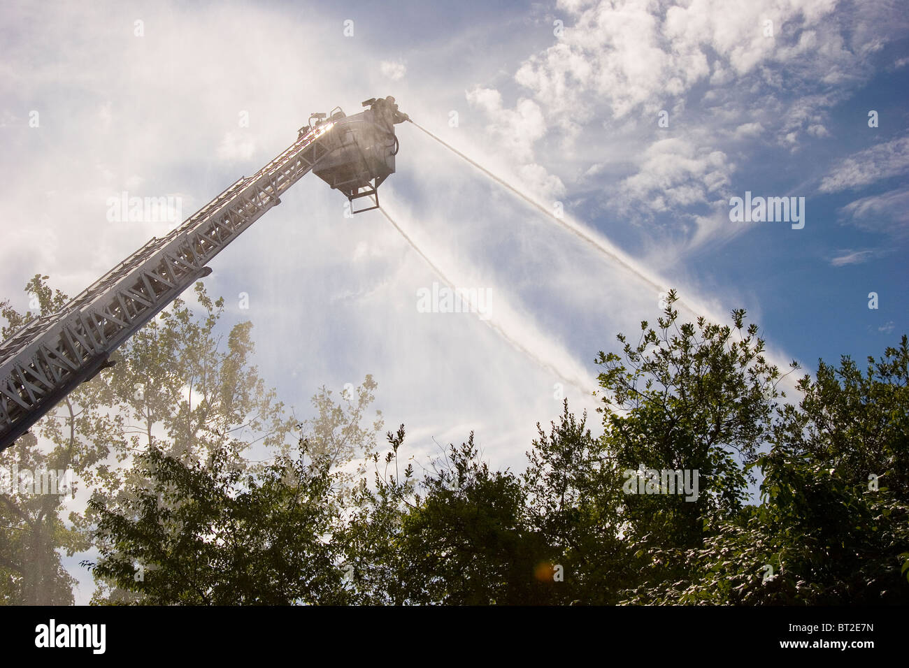 Firefighters training from ladder on ladder truck, with hoses, New ...