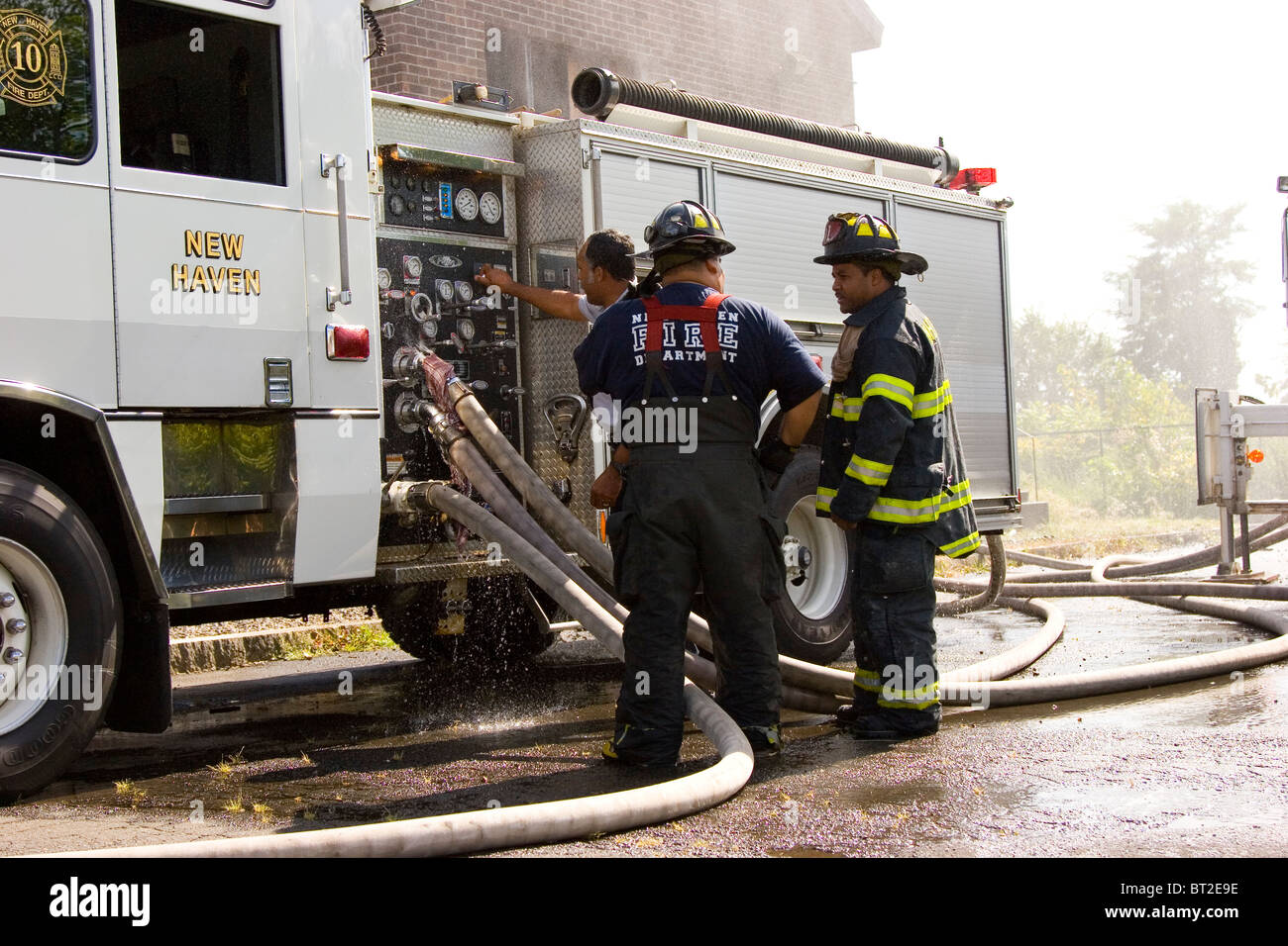 Firefighters training with hoses, firetruck and ladder truck, New Haven ...