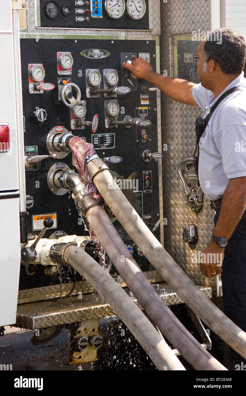 Firefighter operating hoses on fire truck, New Haven, Connecticut, USA ...