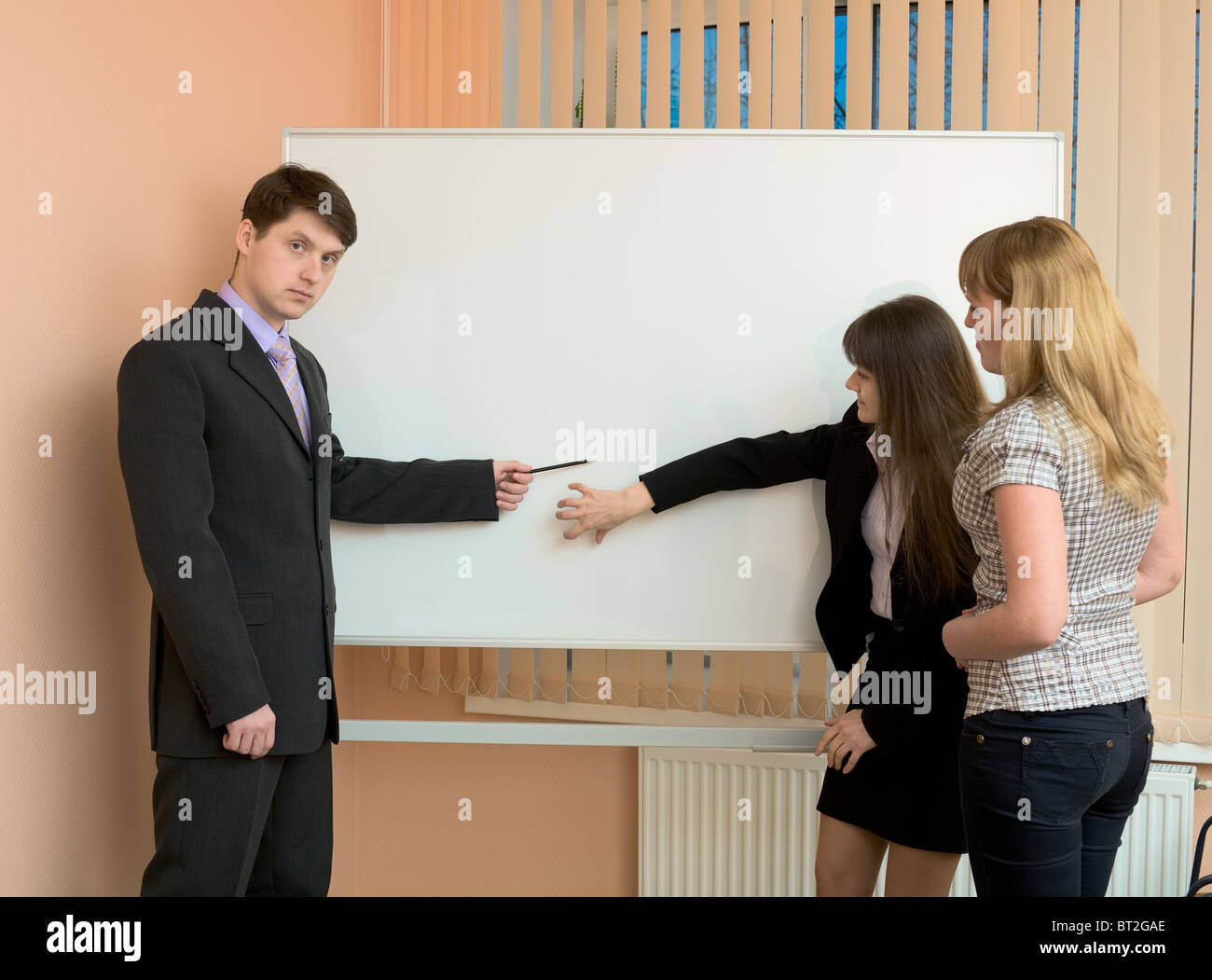 Office workers discuss work standing at a board Stock Photo - Alamy