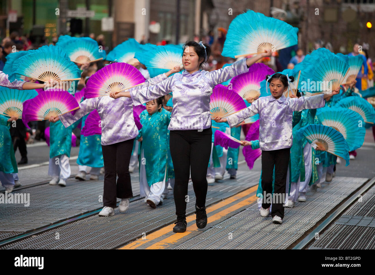 Chinese woman leading a group of children in fan performance during ...