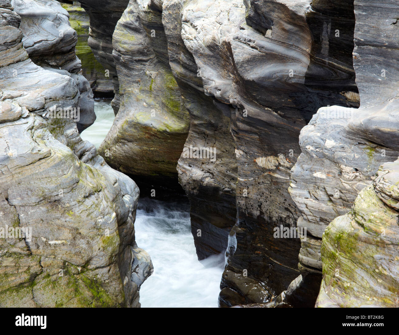 Rocks sculpted by the River Dee as it is forced through a narrow gorge ...