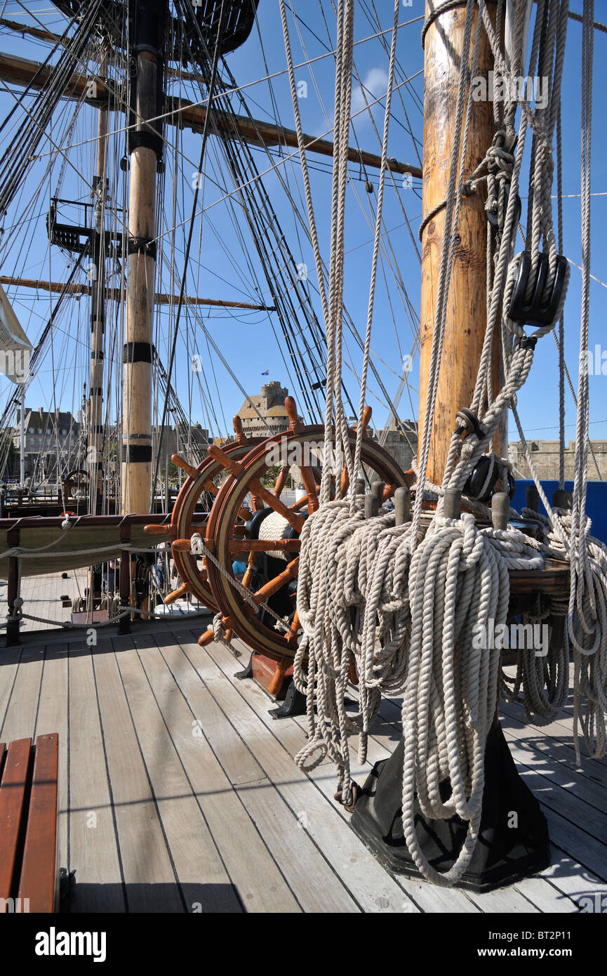 Steering wheel and ropes coiled around belaying pins aboard the Grand ...
