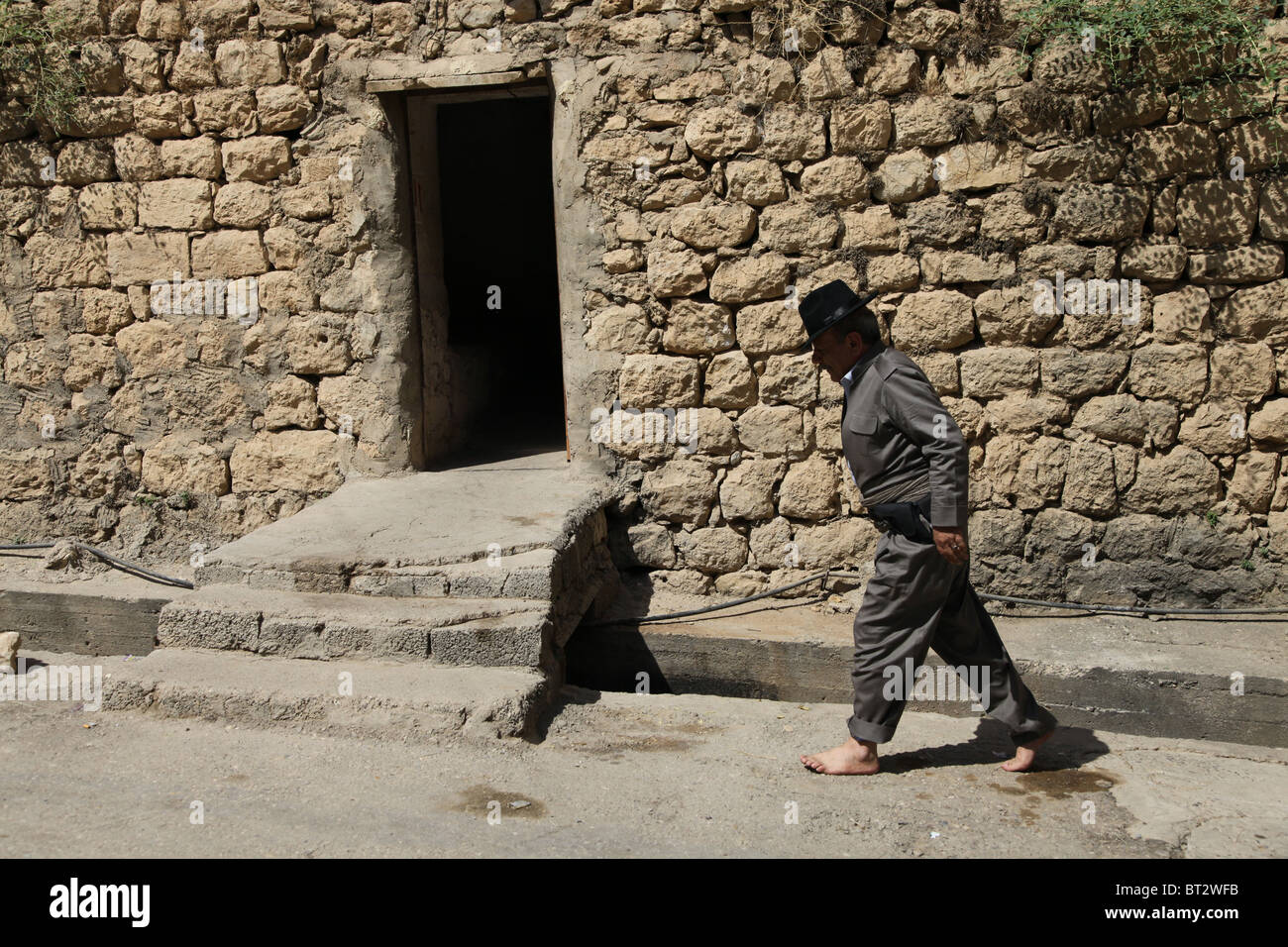 A barefoot Yazidi man walking outside the tomb shrine of Sheikh Adi ibn ...