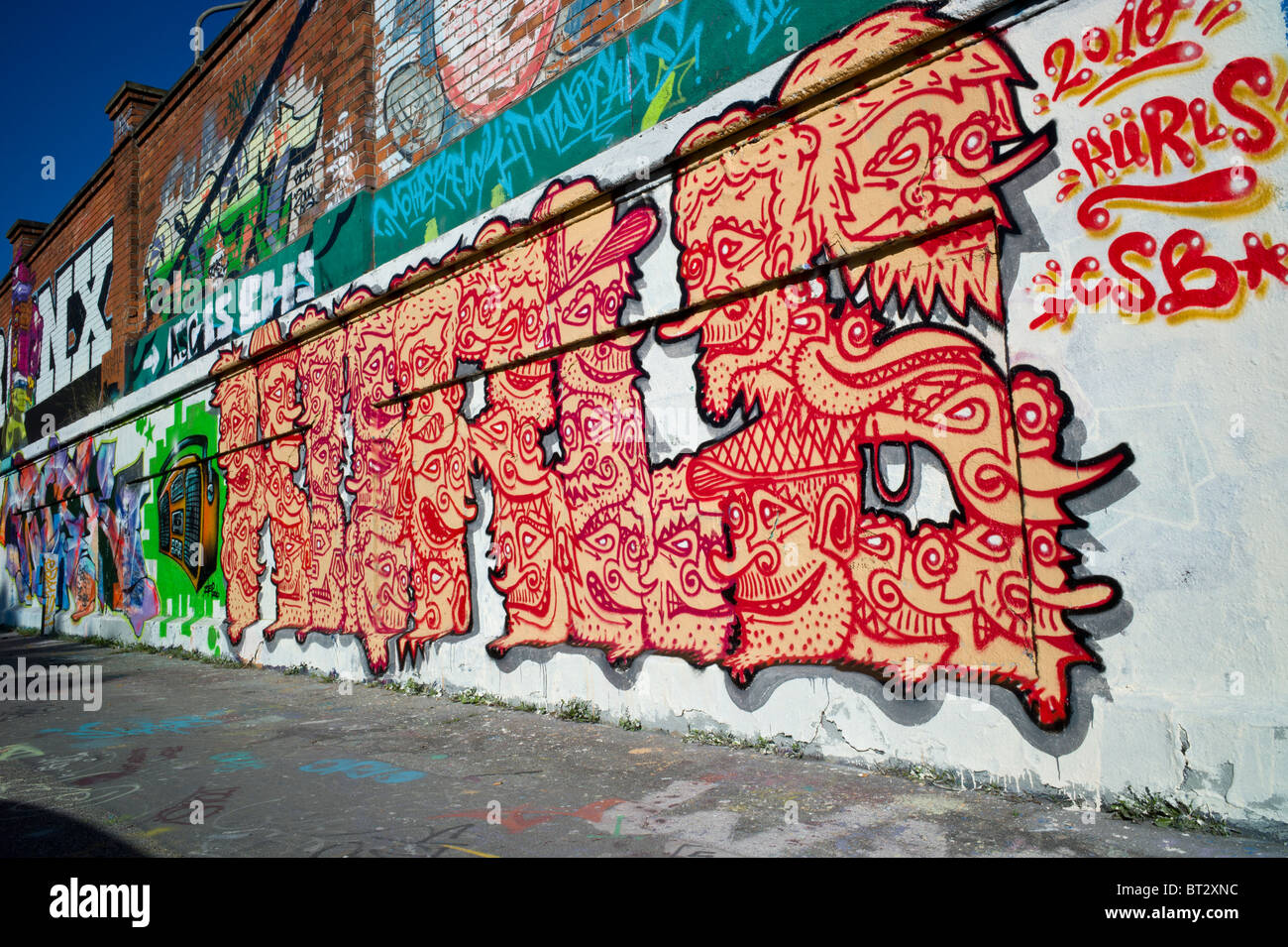 Wall covered with graffiti showing Asian style like piece made of faces ...
