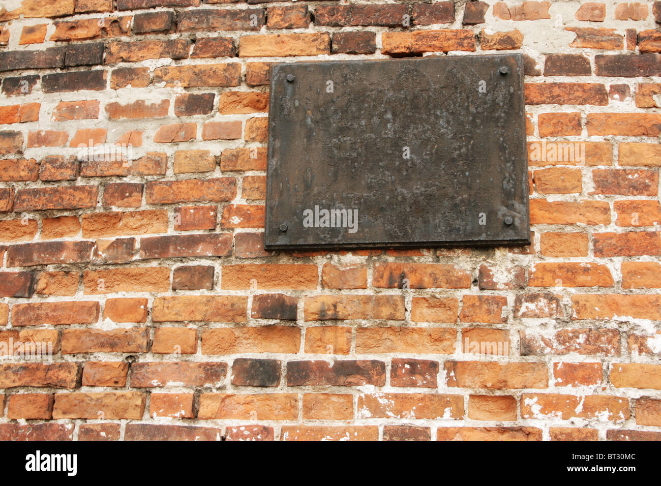 The ancient metal tablet on a stone wall Stock Photo - Alamy