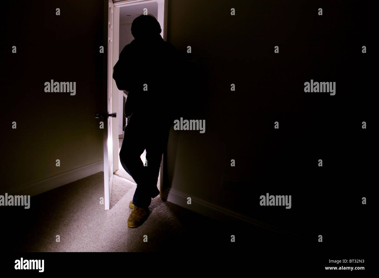 Man standing in the shadows of a dark room, arms folded Stock Photo - Alamy