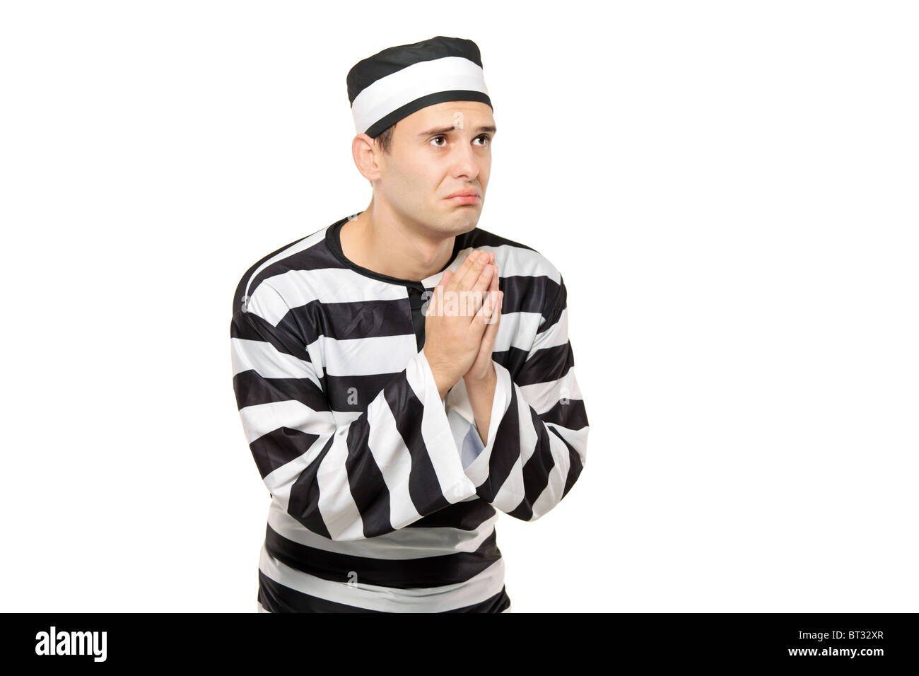 A sad prisoner with both hands clasp in begging gesture Stock Photo - Alamy