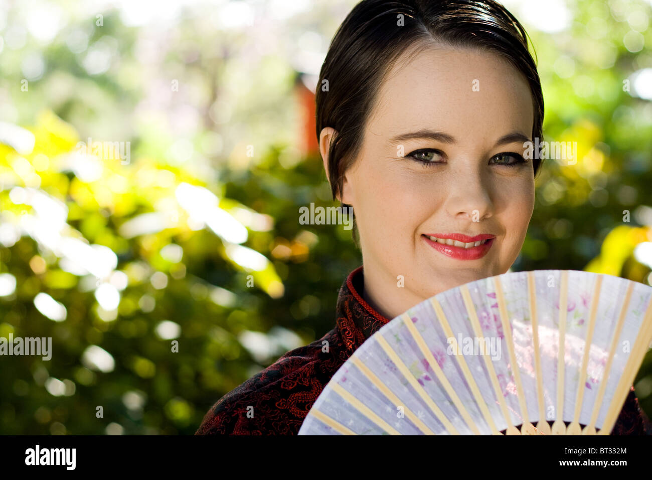 young beautiful woman with a Chinese fan Stock Photo - Alamy